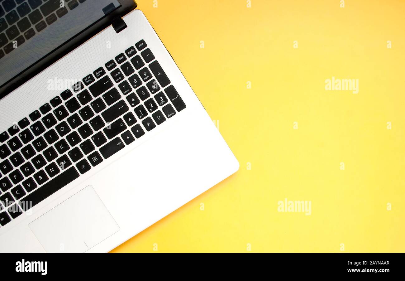 Black-white laptop keyboard on an orange background. Flat lay. Top view ...