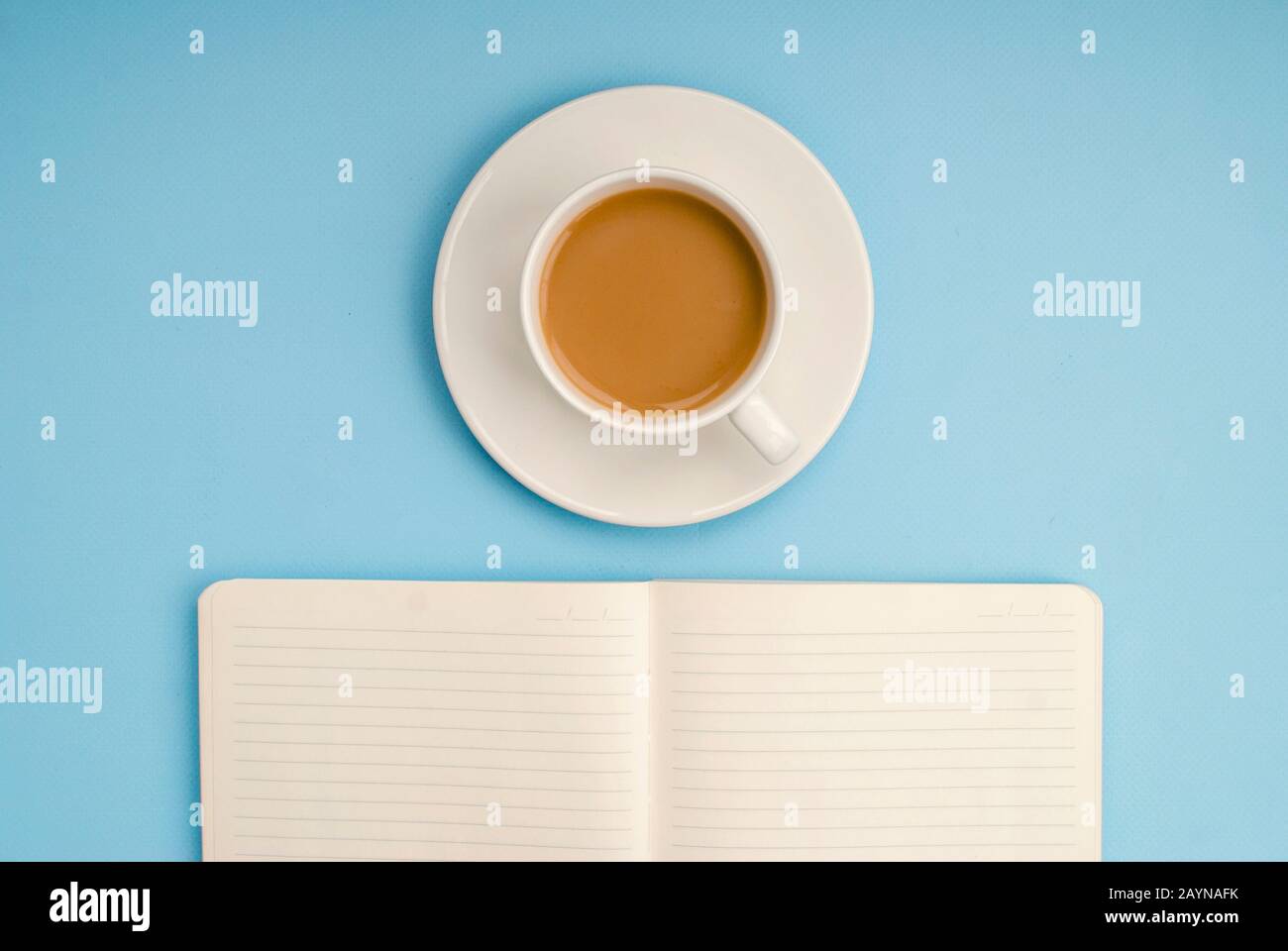 White open notebook for notes, a white cup of coffee with milk on a ...