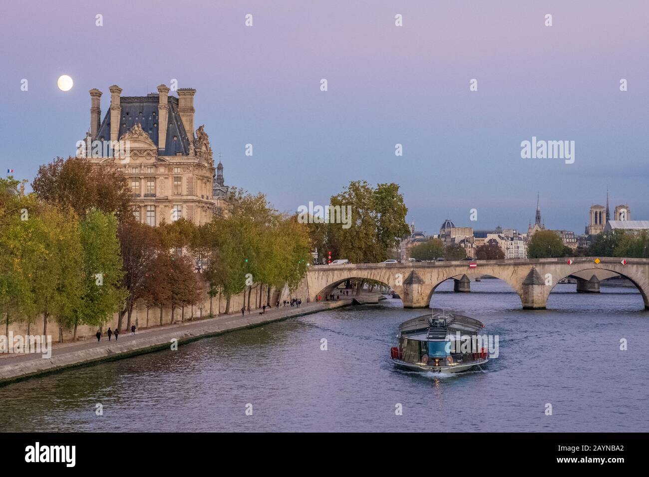 A riverboat on the River Seine with a full moon in the background in ...