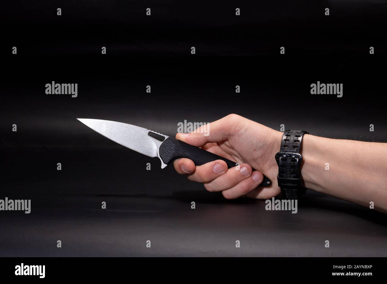 Knife in hand. Pocket knife in hand. Knife and clock on hand. Black ...