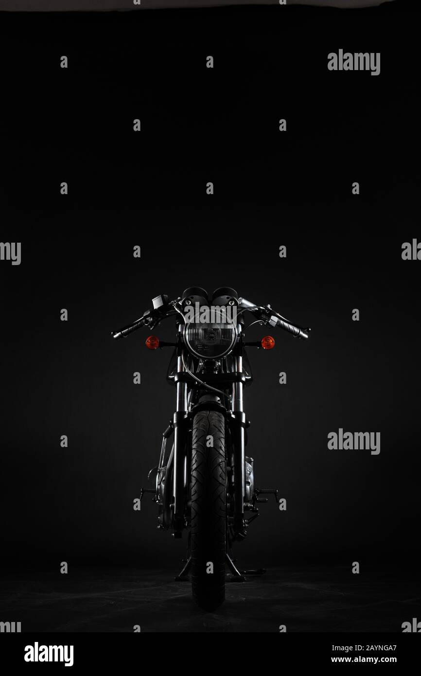 a classic black motorcycle in front of a black studiobackdrop Stock ...
