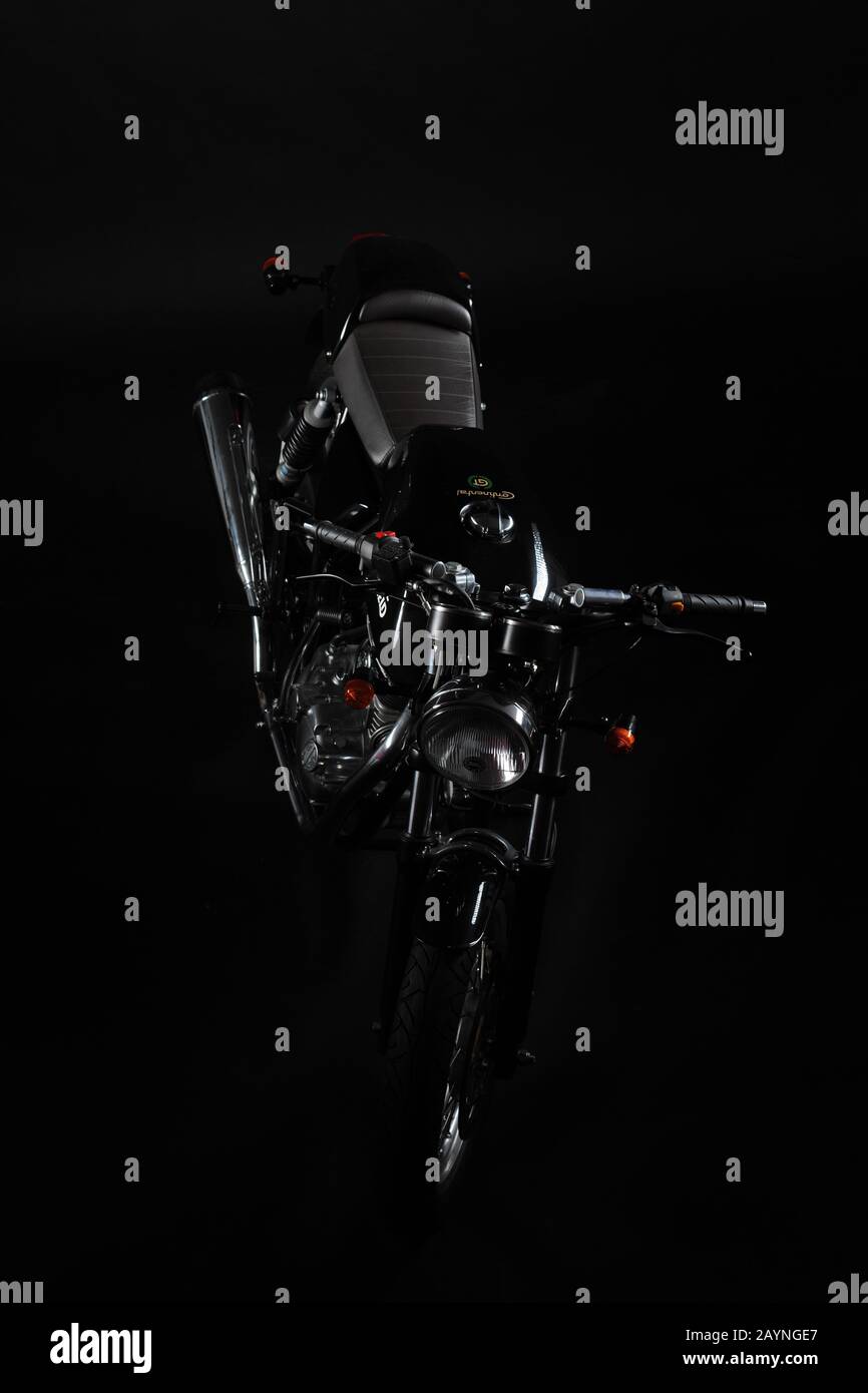 a classic black motorcycle in front of a black studiobackdrop Stock ...