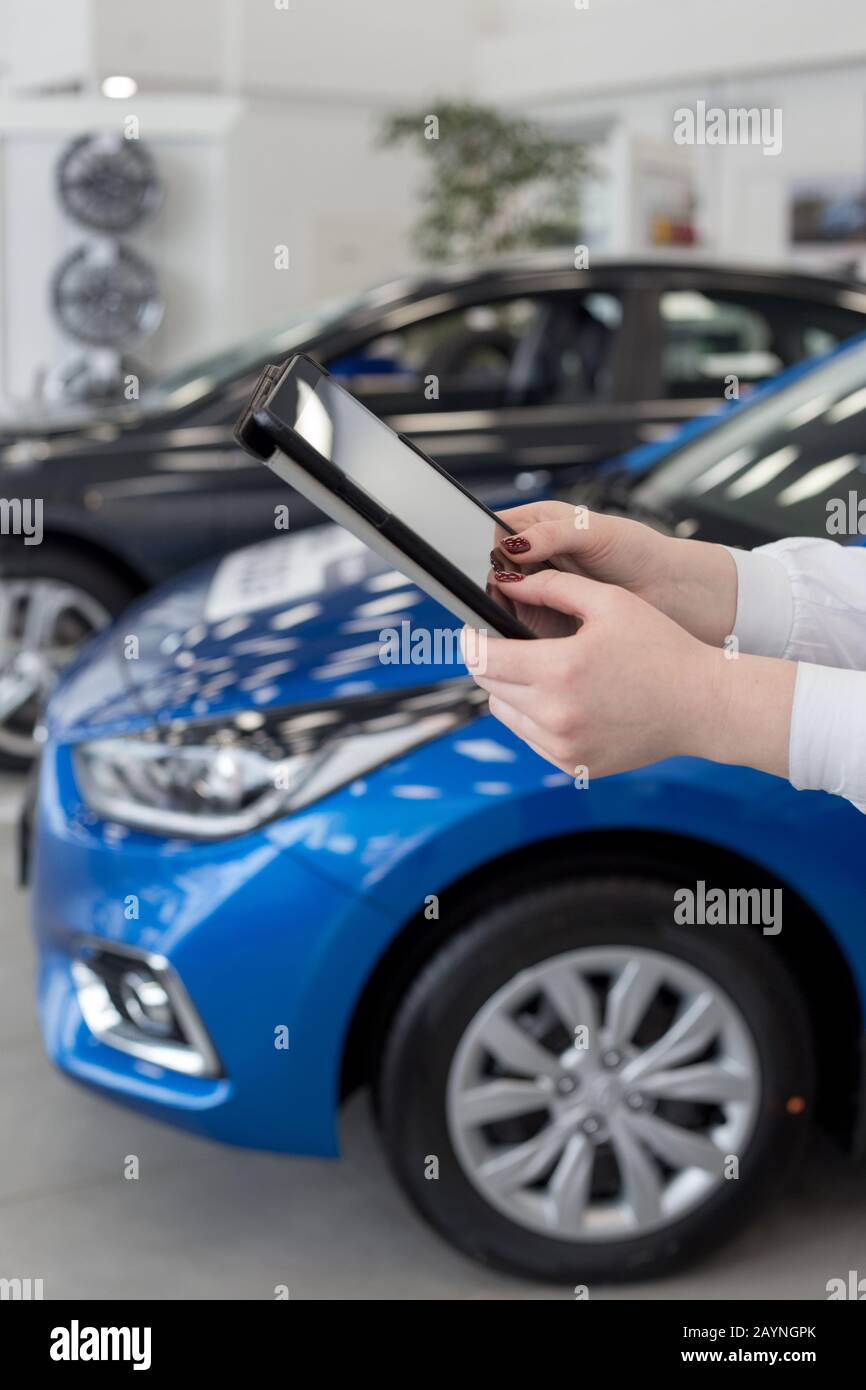 Woman dealer using digital tablet at dealer showroom. Touching screen ...