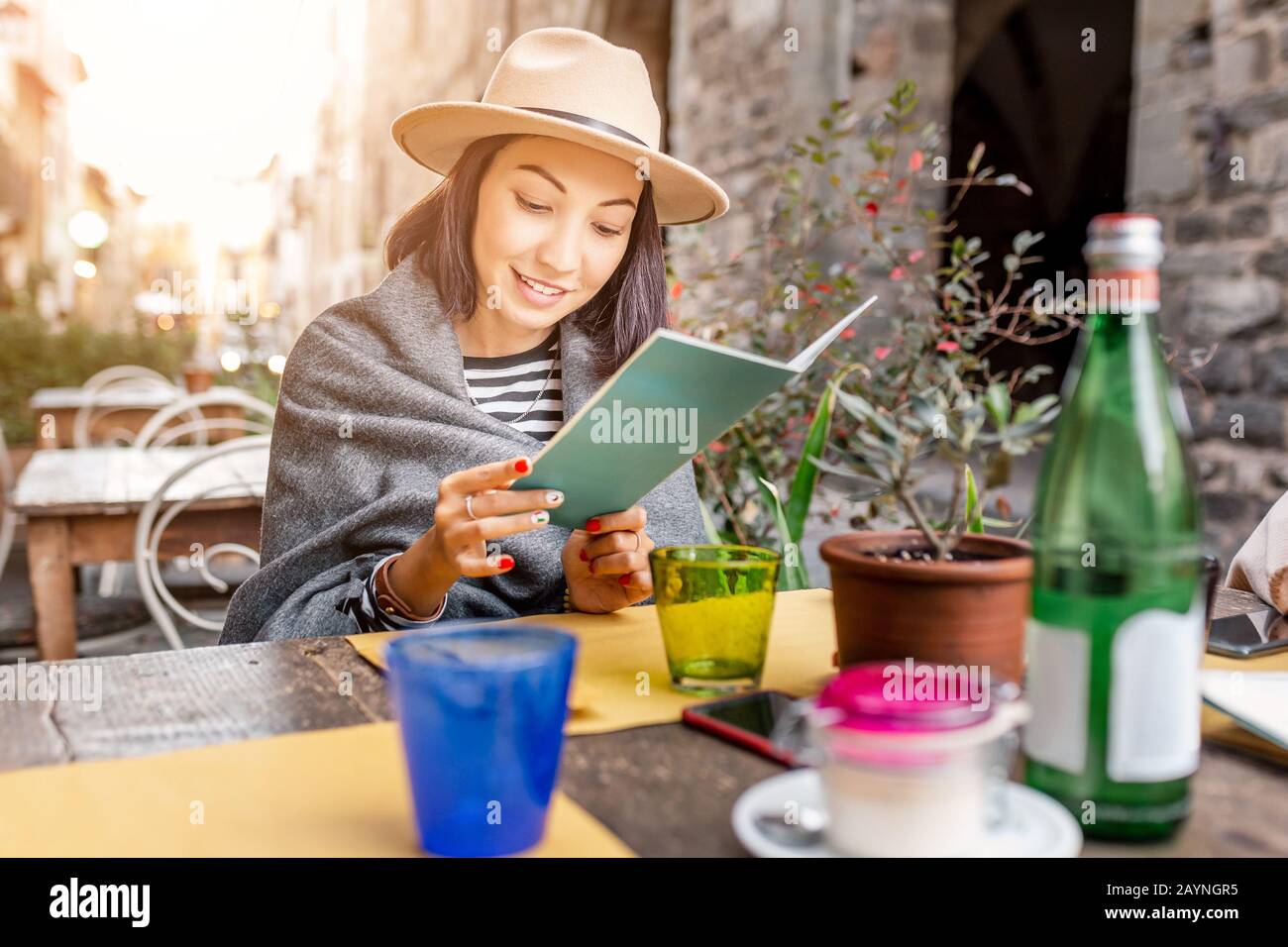 Asian woman open menu for ordering food in outdoor restaurant Stock ...