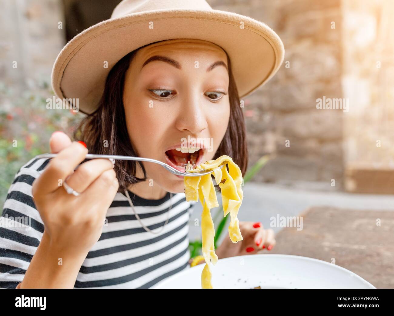 young asian traveler woman eating italian pasta in old town at the ...