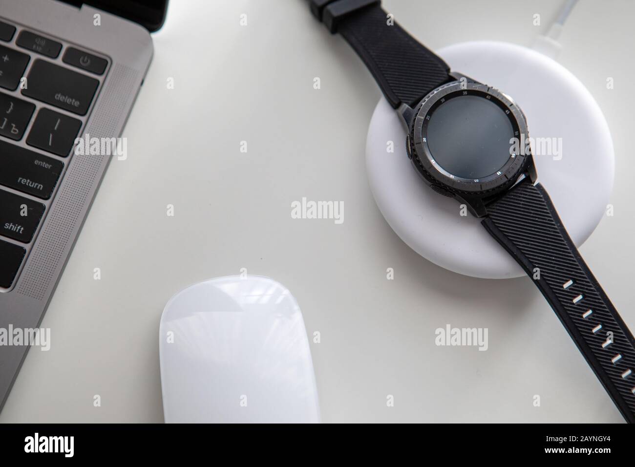 overhead view of computer mouse with laptop and smart watch on wireless ...