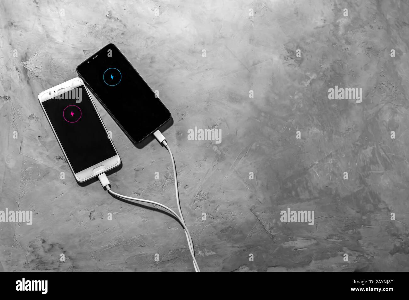 Two phones are charging with intertwined wires. concept love, together ...