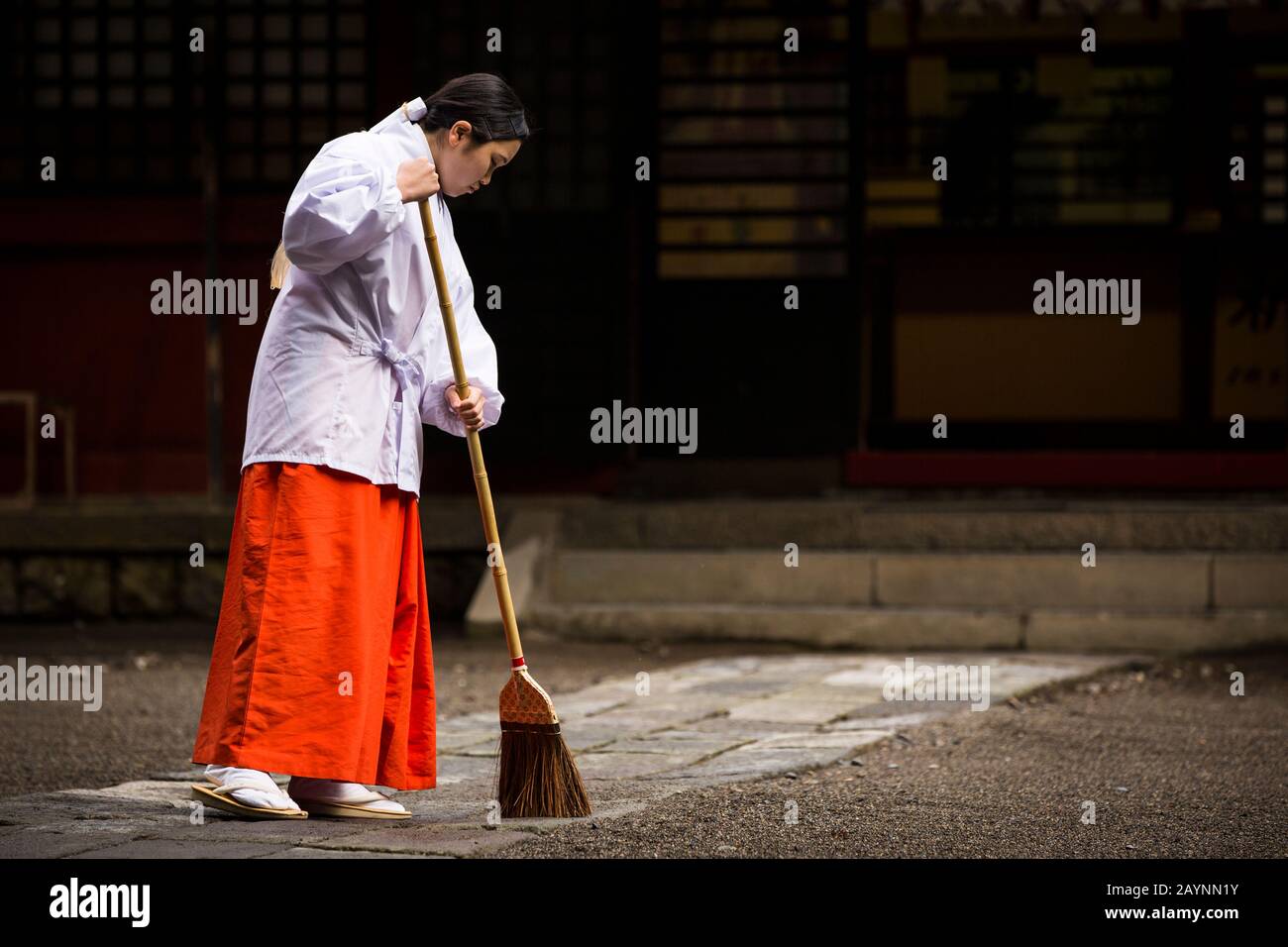 Nun cleaning outside Futarasan Jinja shrine. Nikko, Japan Stock Photo ...