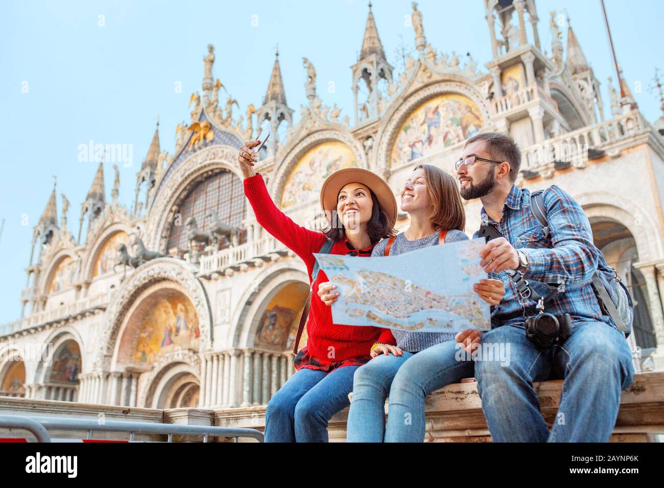 Group of happy friends travelers with map on San Marco Square in Venice ...