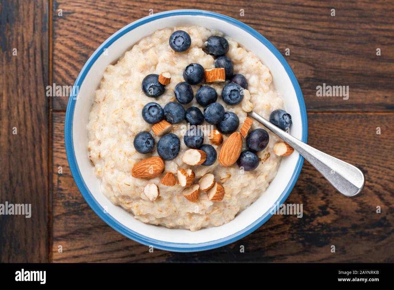 Oatmeal porridge bowl with blueberries and chopped almonds on rustic ...
