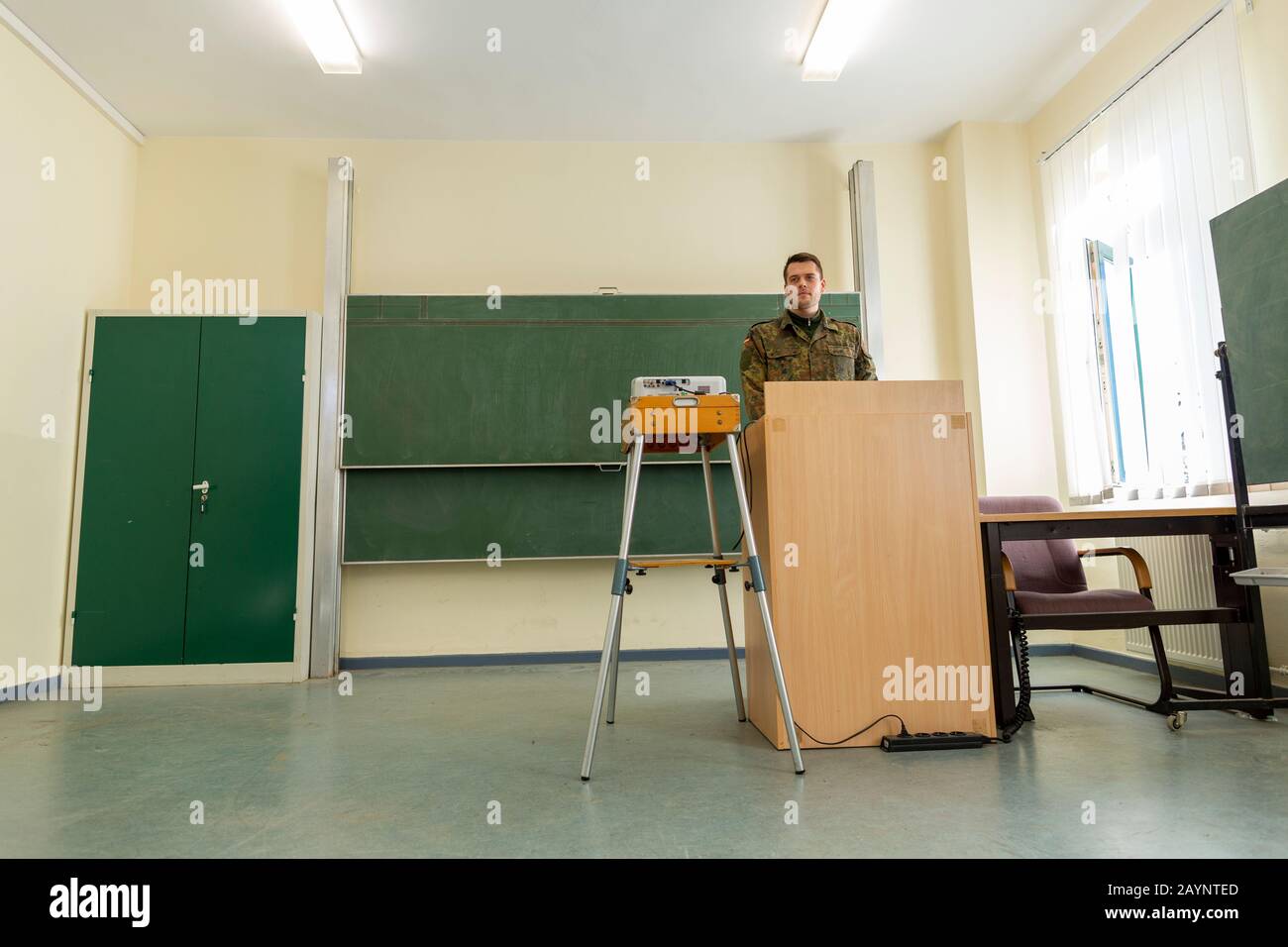 German soldier stands in a classroom . German word Bundeswehr, means ...