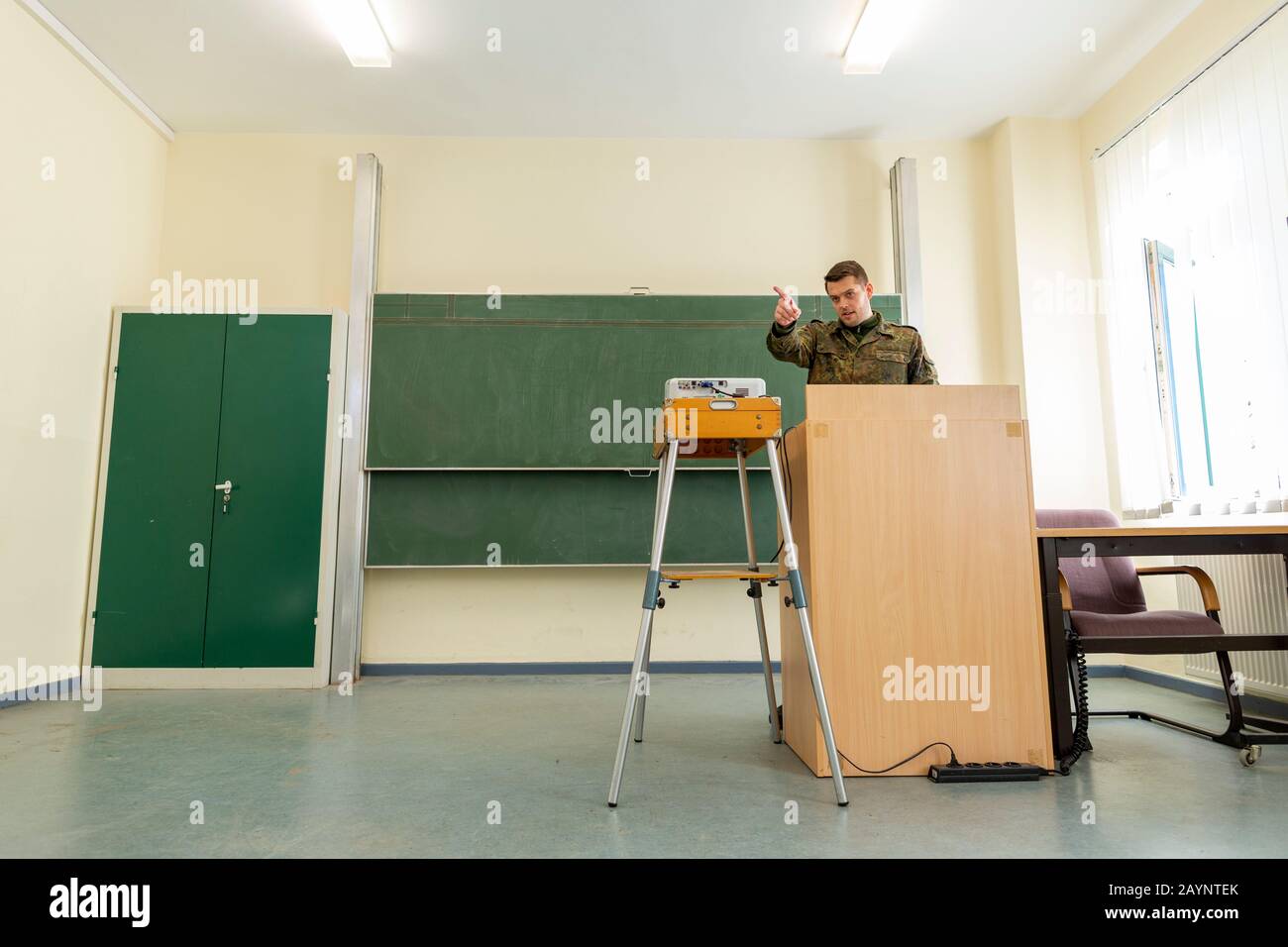 German soldier stands in a classroom . German word Bundeswehr, means ...