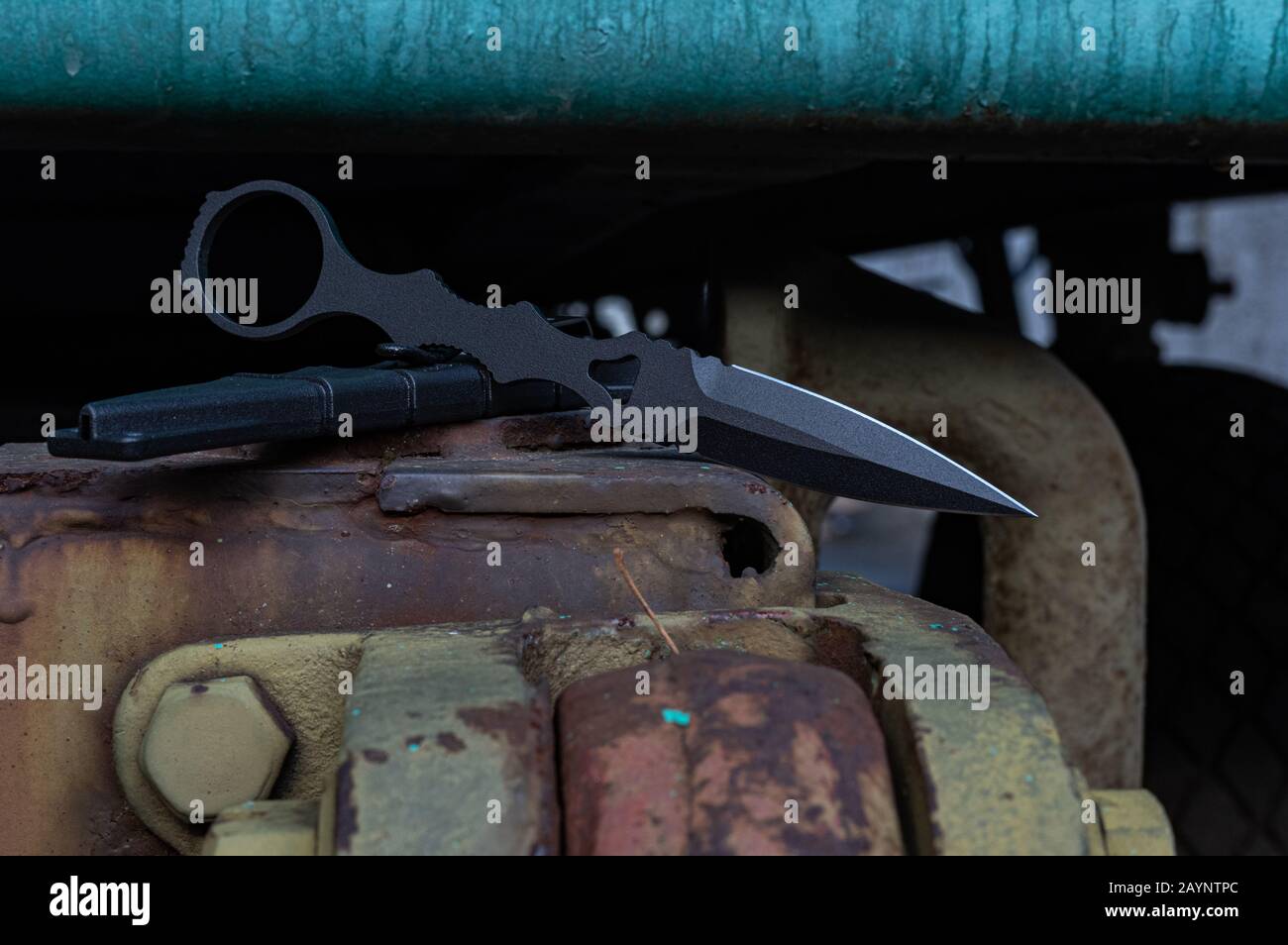 Black metal knife for the military. Military knife on a military car ...