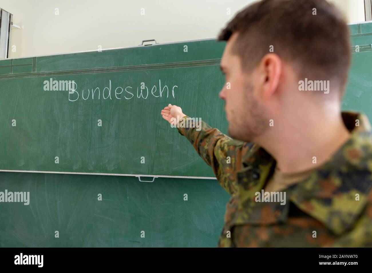 German soldier stands in a classroom . German word Bundeswehr, means ...