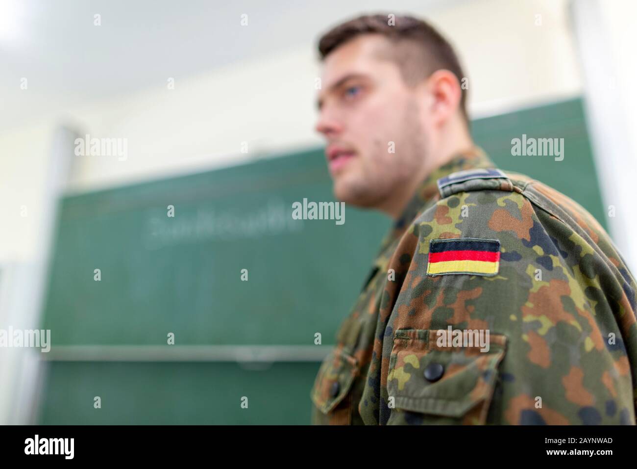 German soldier stands in a classroom . German word Bundeswehr, means ...