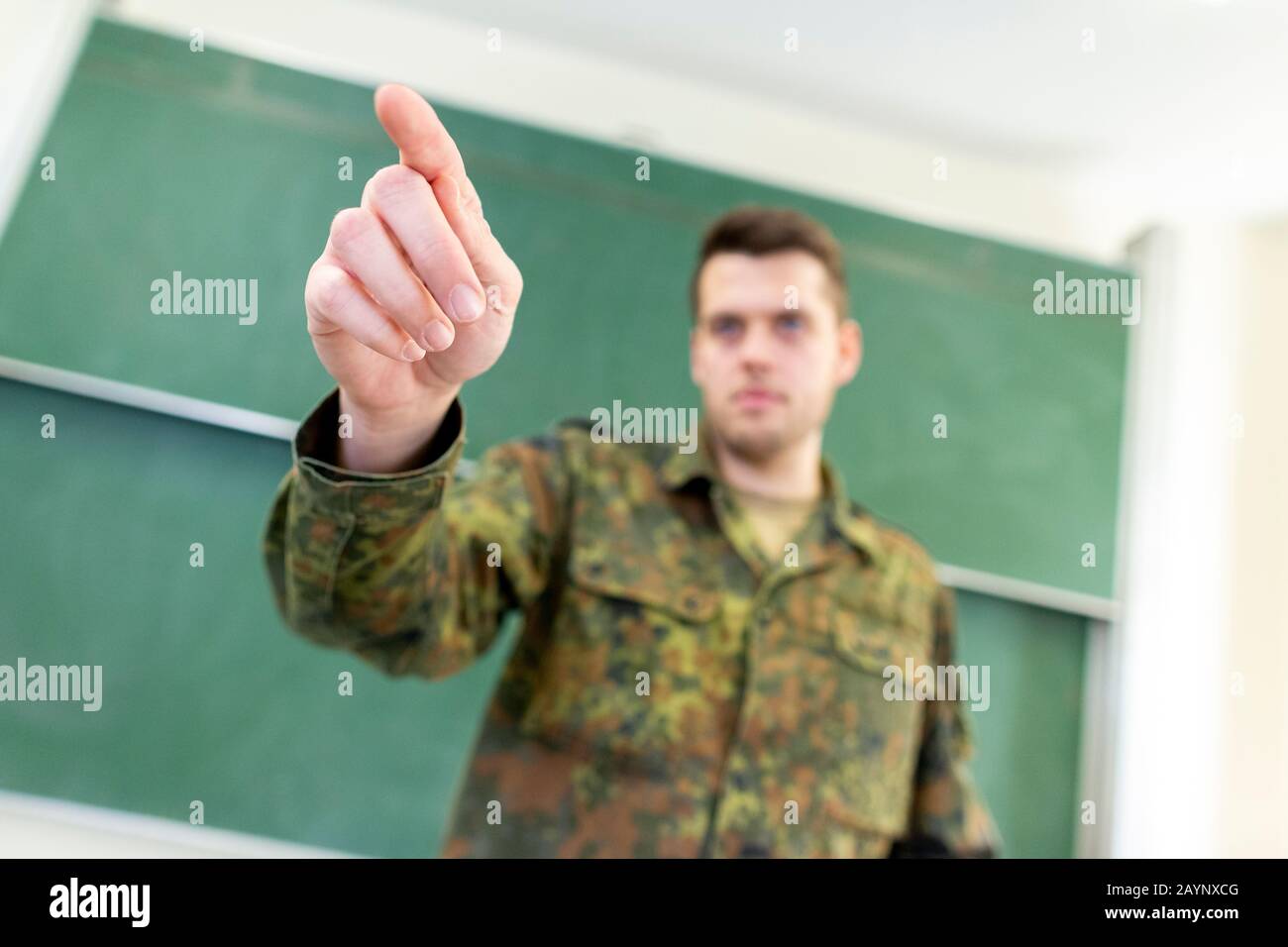German soldier stands in a classroom . German word Bundeswehr, means ...