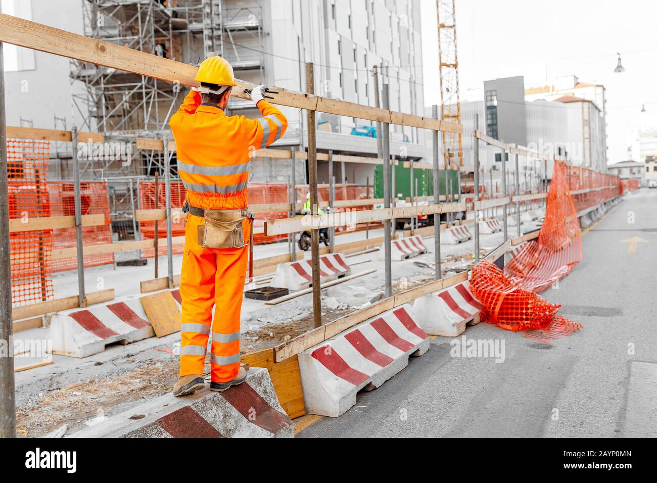 Construction worker in orange safety uniform and helmet working at the ...