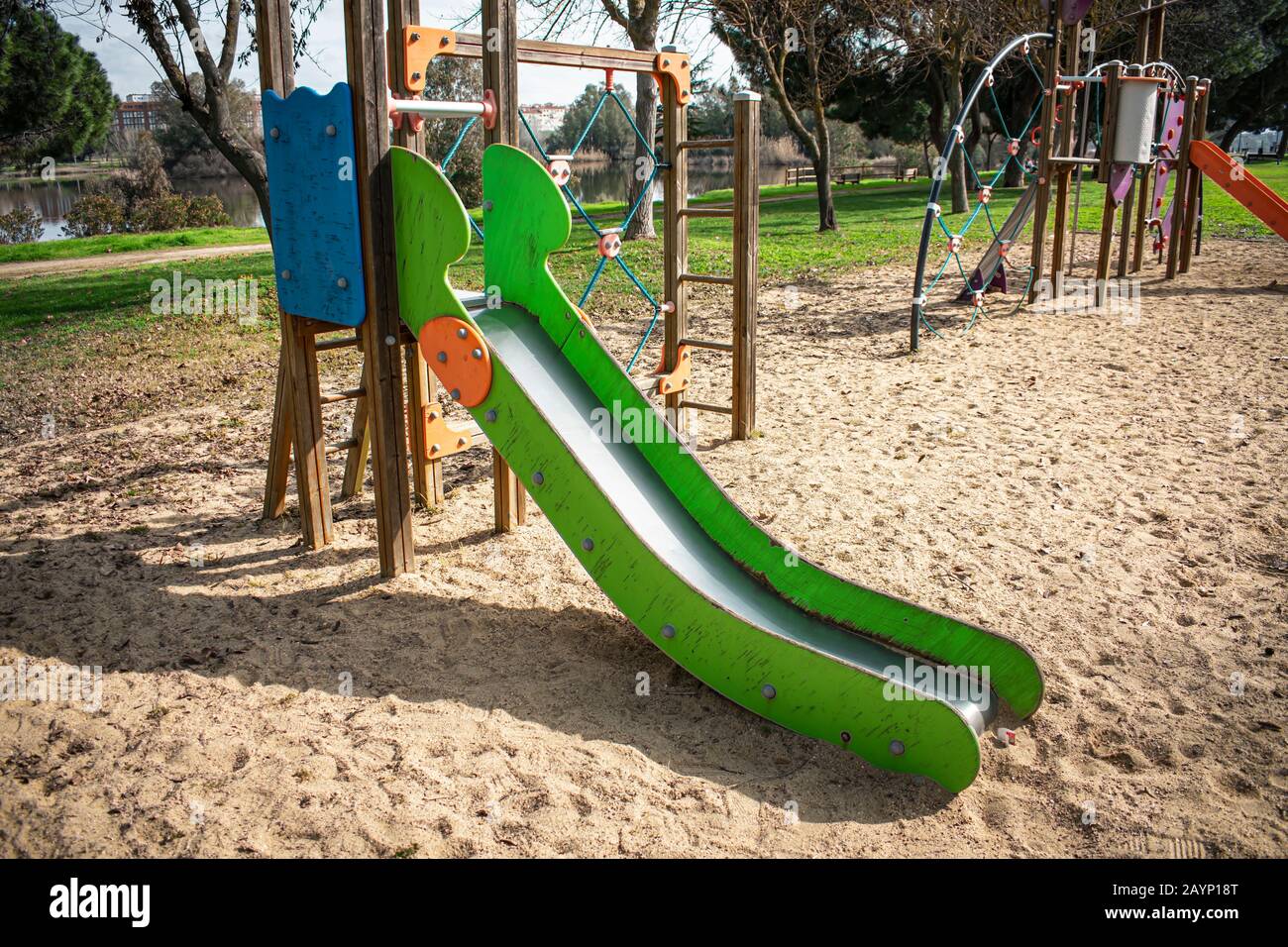 children's slide located in a public park with grass and trees Stock ...