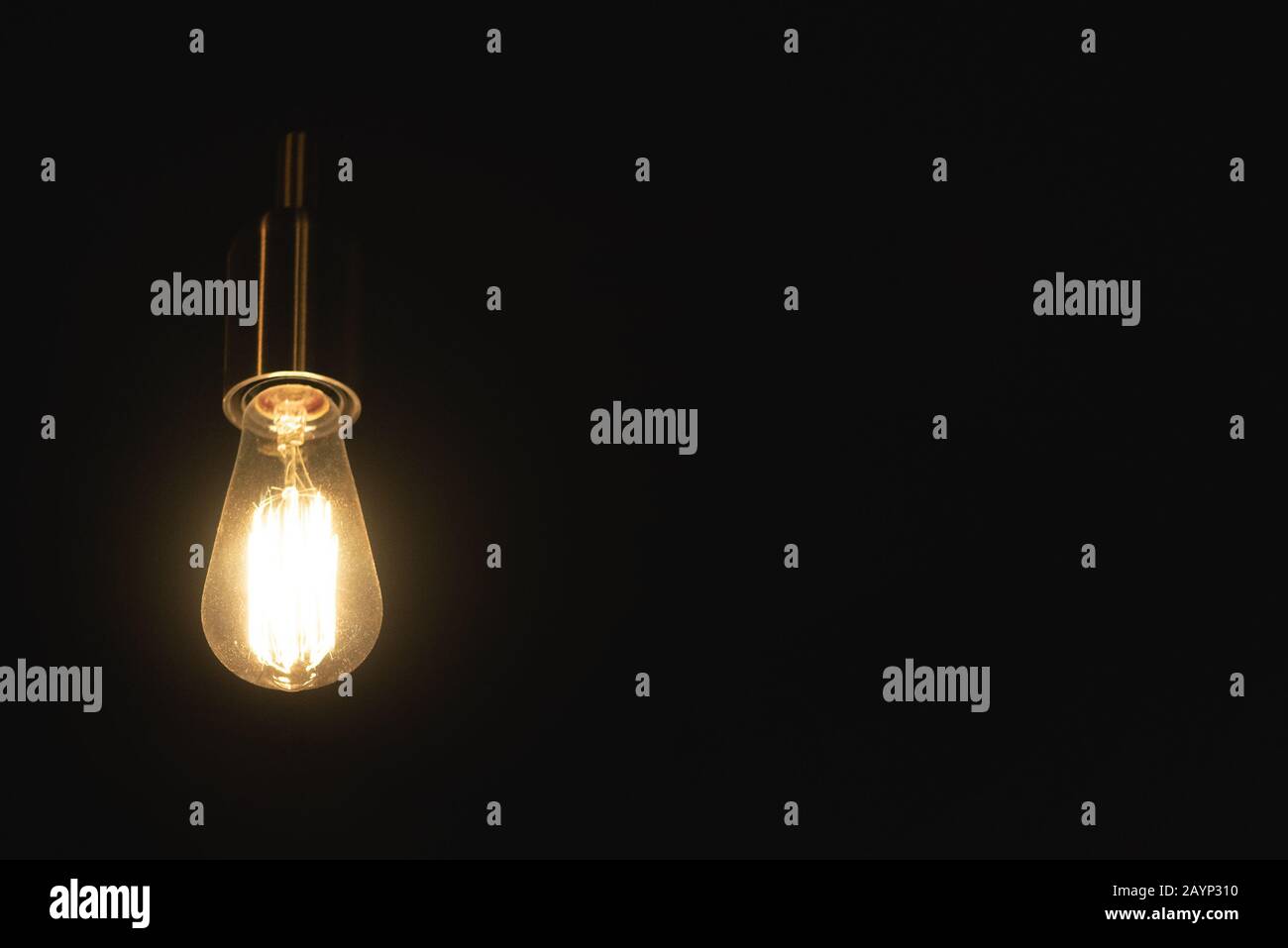 Burning lamp on black background with copy space Stock Photo - Alamy