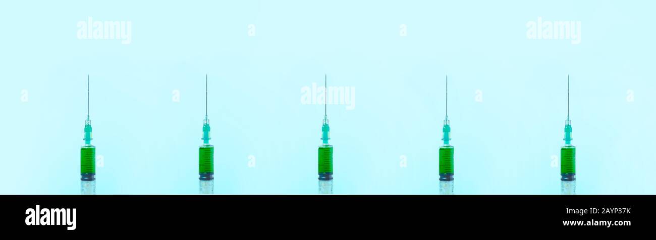 green liquid in a syringes on a blue background, concept of antiviral ...
