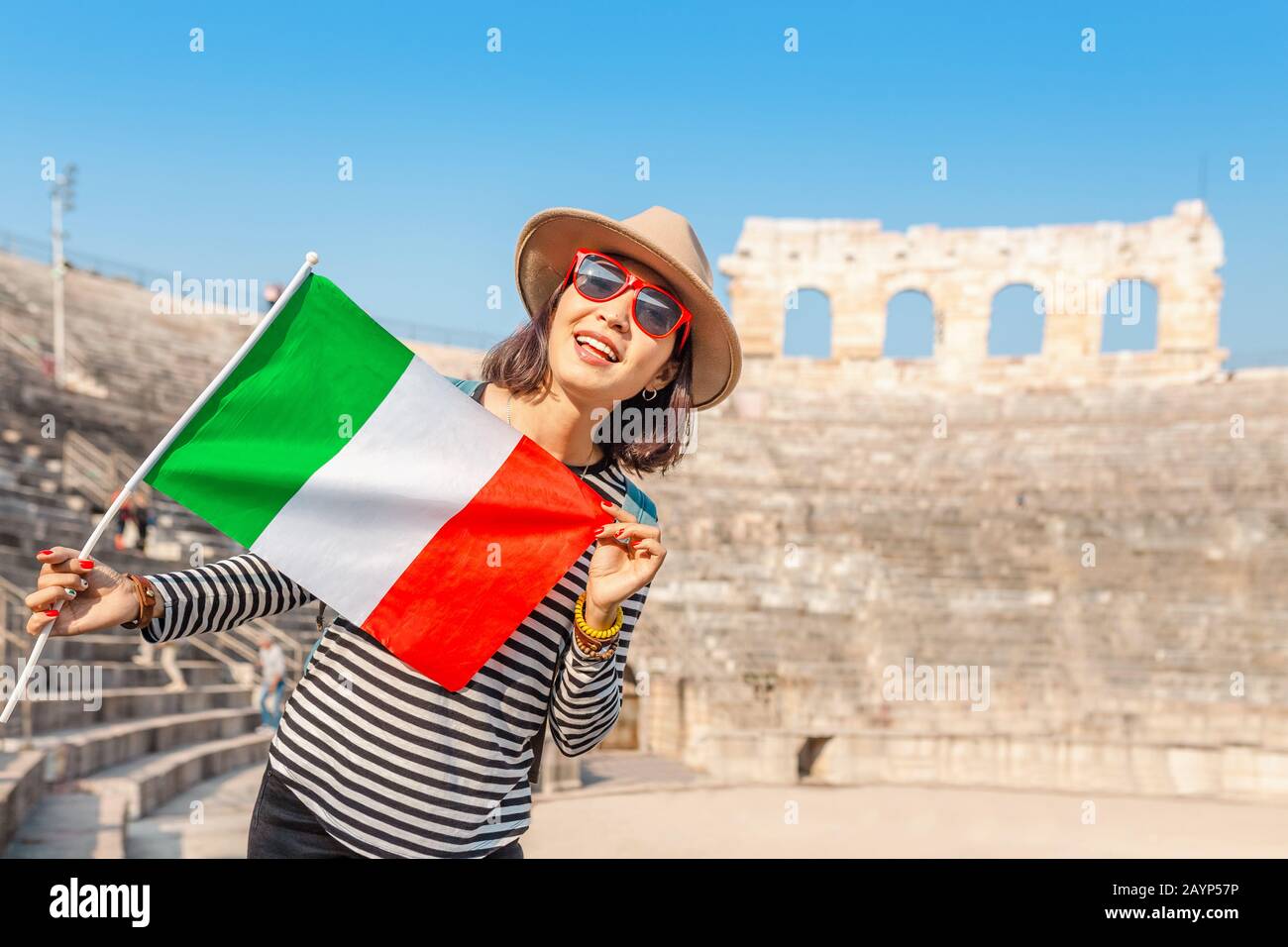 happy young asian woman with italian flag in front of the famous ...