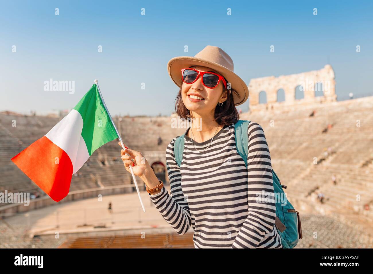 happy young asian woman with italian flag in front of the famous ...