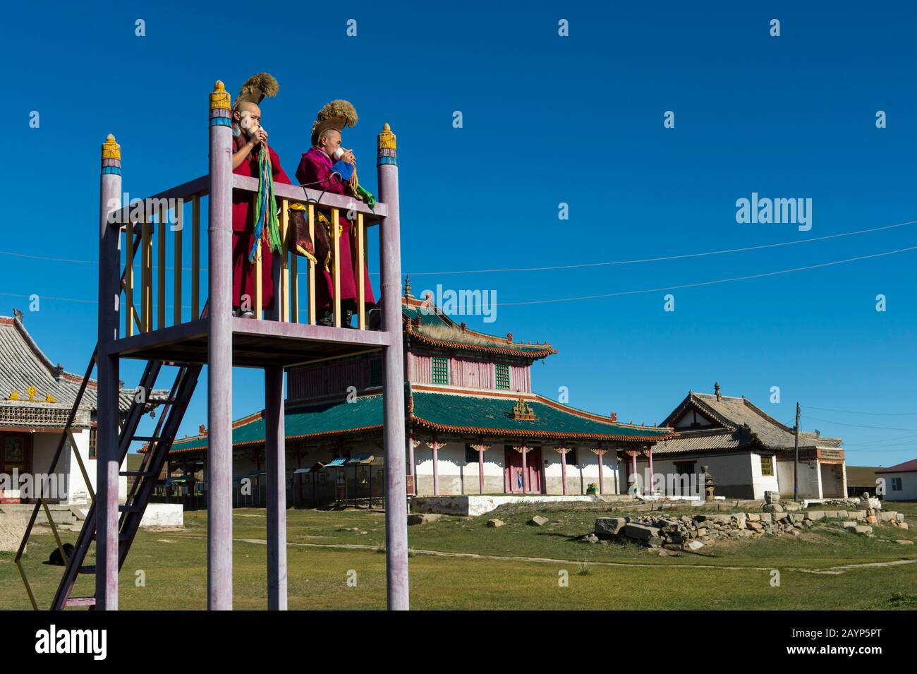 Young monks blowing a conch shell to call the monks for prayer at the ...