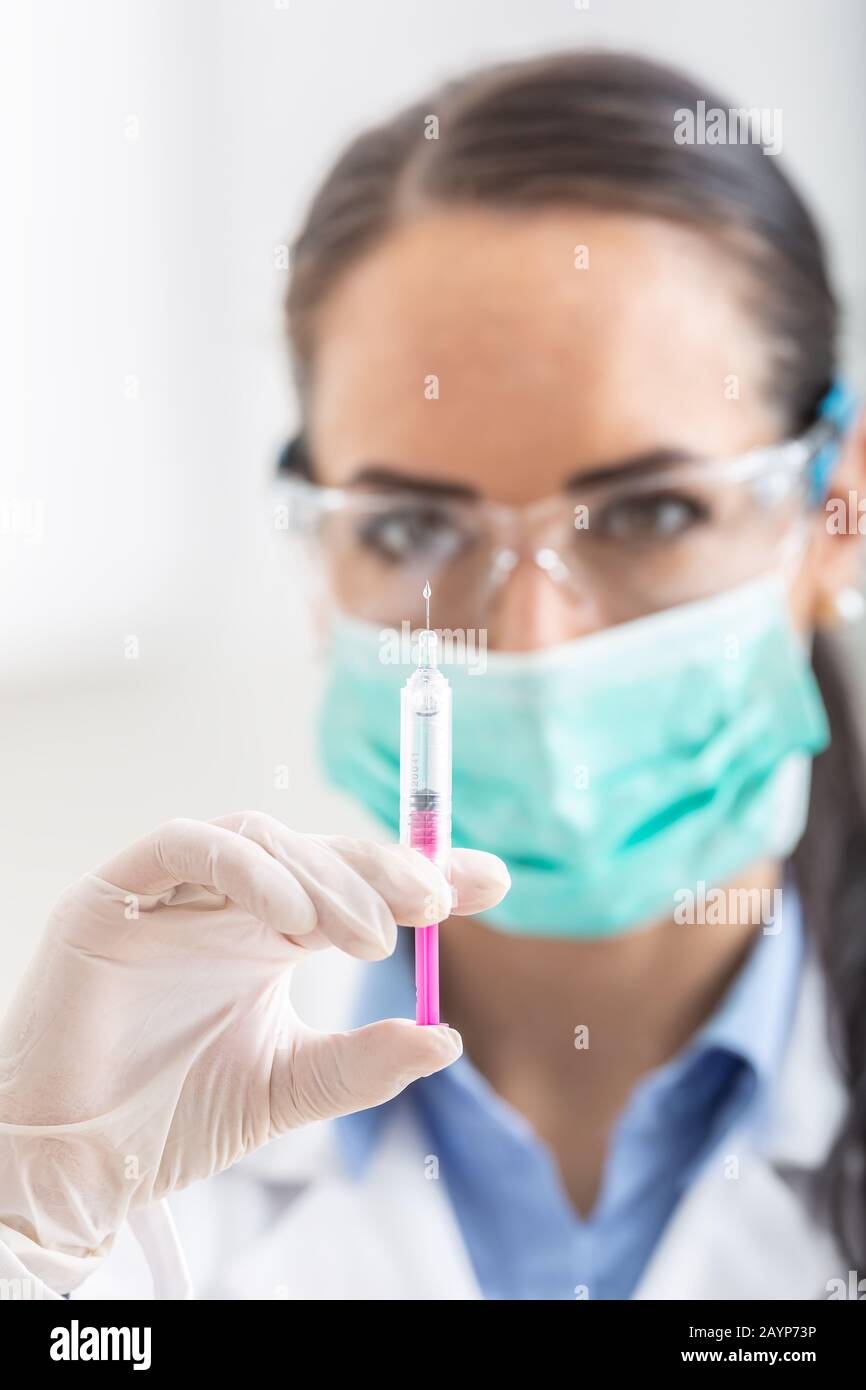 Female doctor working with syringe needle and ampoule of medicine. A ...