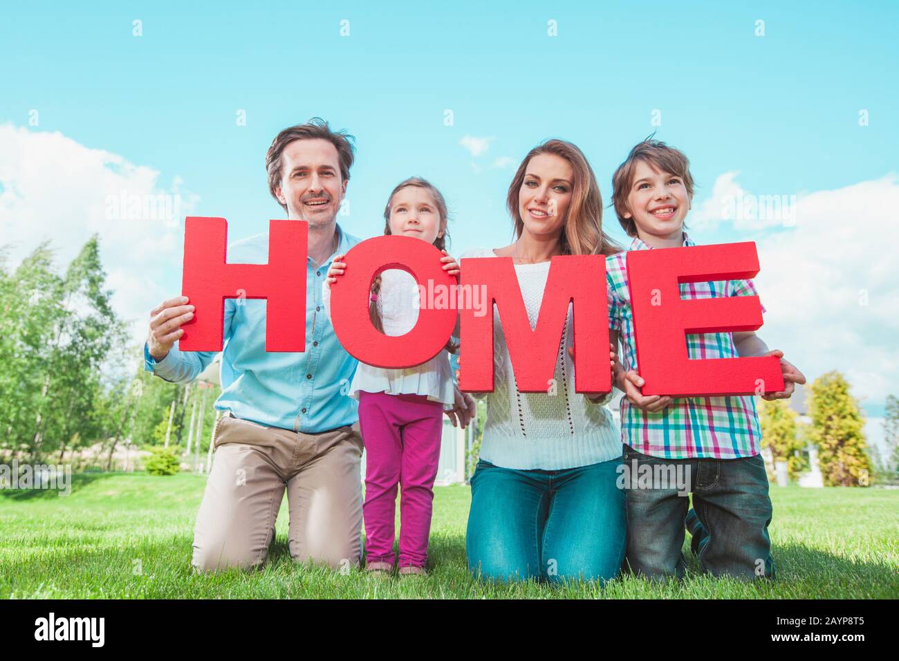 Happy family holding HOME letters in front of their house Stock Photo ...