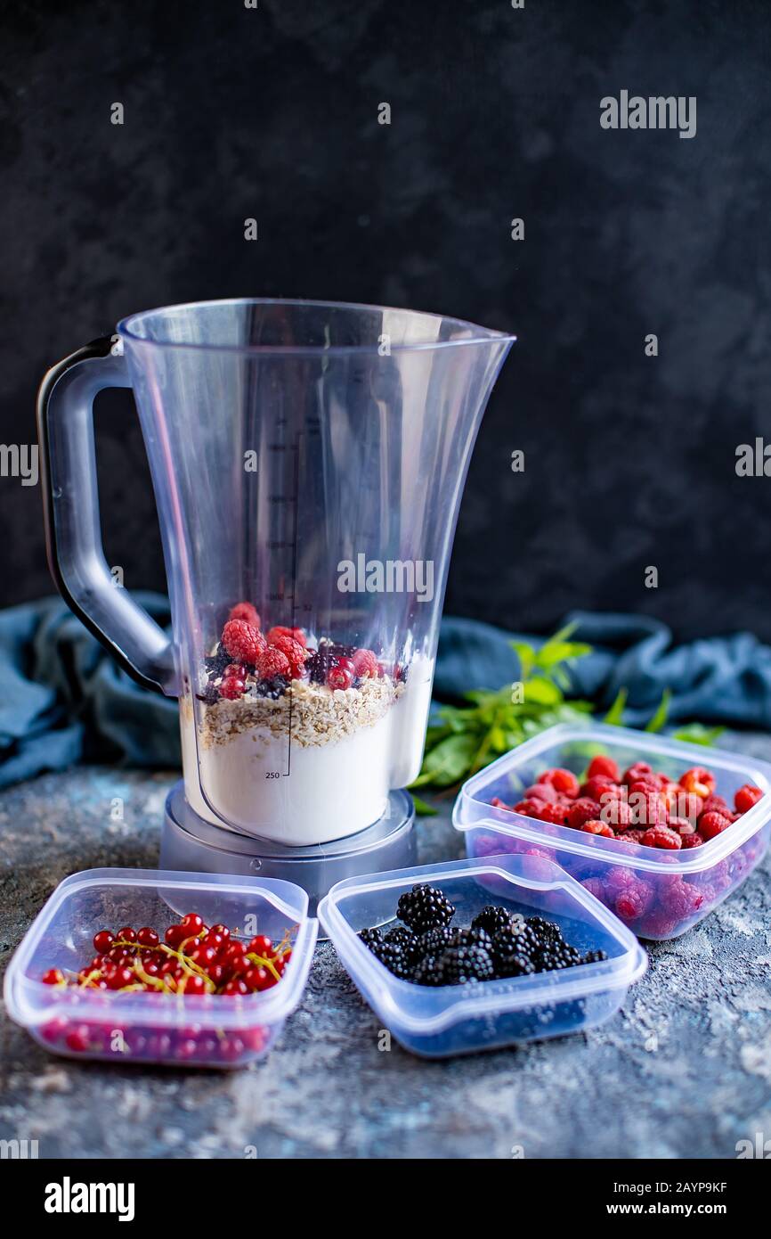 Blender with oatmeal, plastic plates, containers with raspberry ...