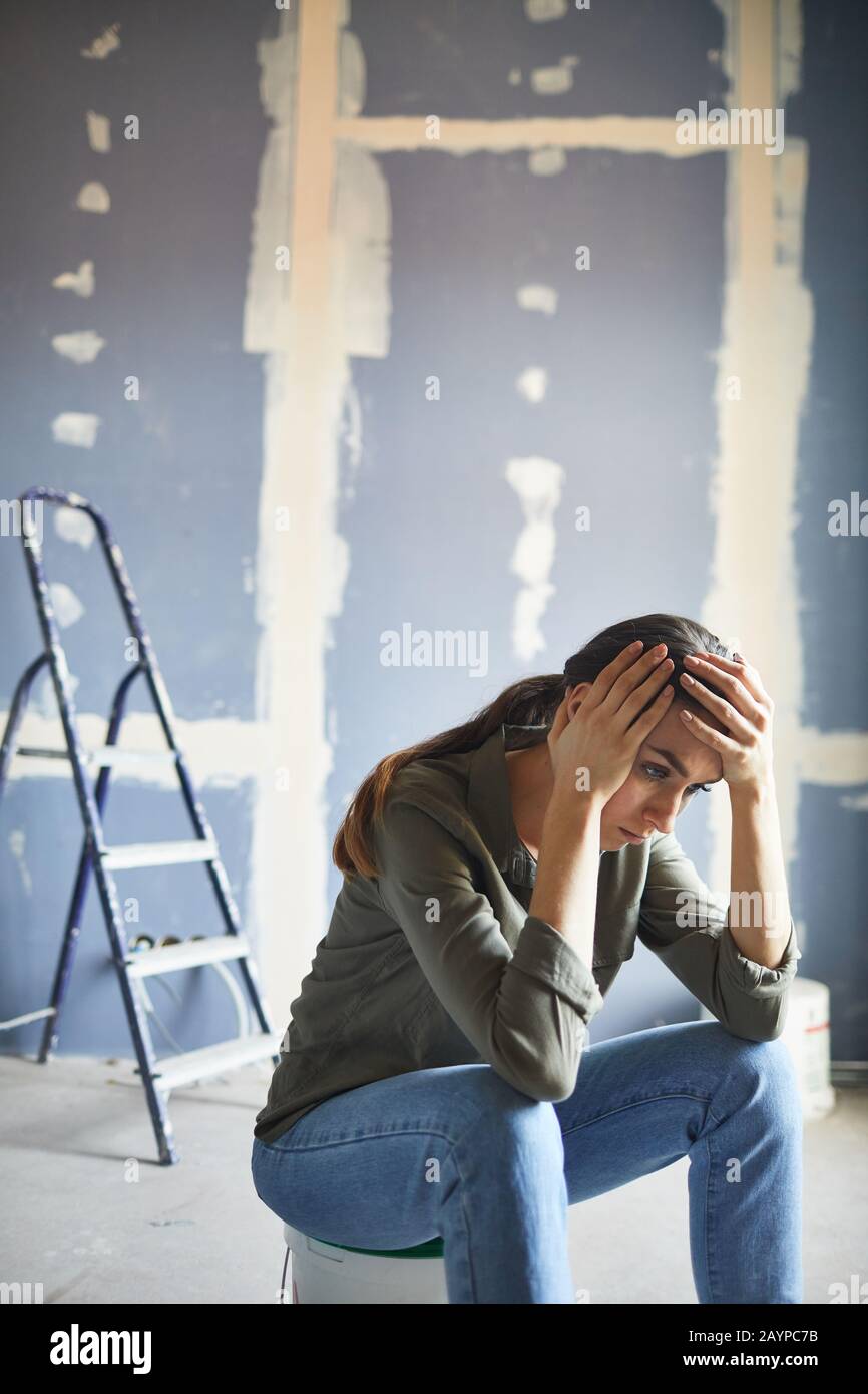 Vertical portrait of frustrated young woman devastated by renovations ...