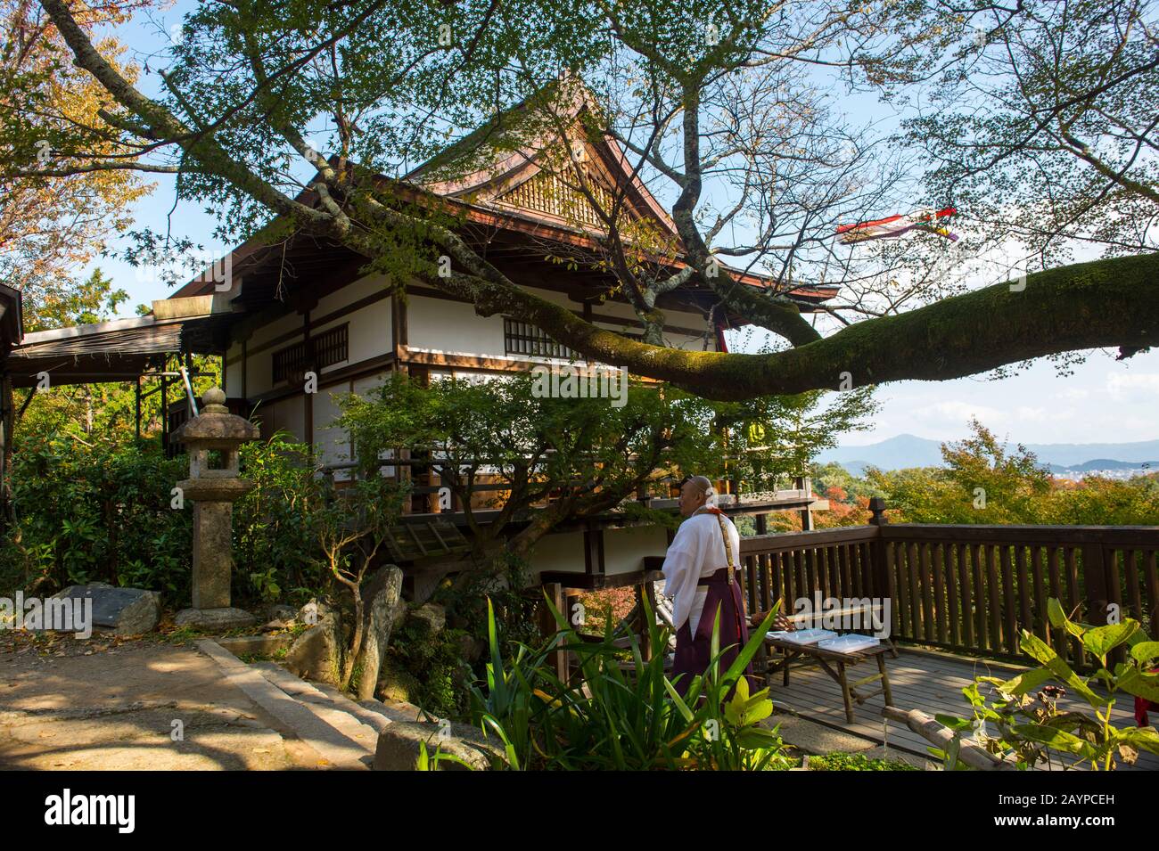 A monk in the garden of the Senkoji Temple in the forest above the ...
