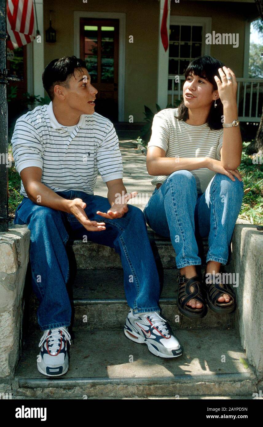 San Antonio, Texas: Hispanic teenage couple sits and talks on front ...