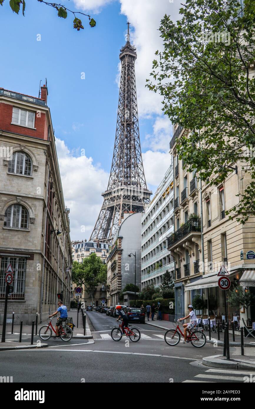 Street scene with cyclists using crosswalk & Eiffel Tower in background ...