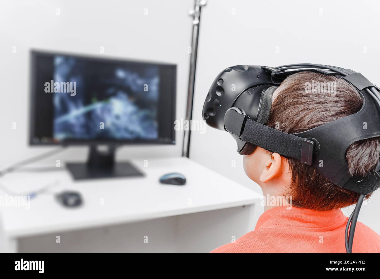 Kid boy playing in virtual reality VR headwear near pc screen Stock ...