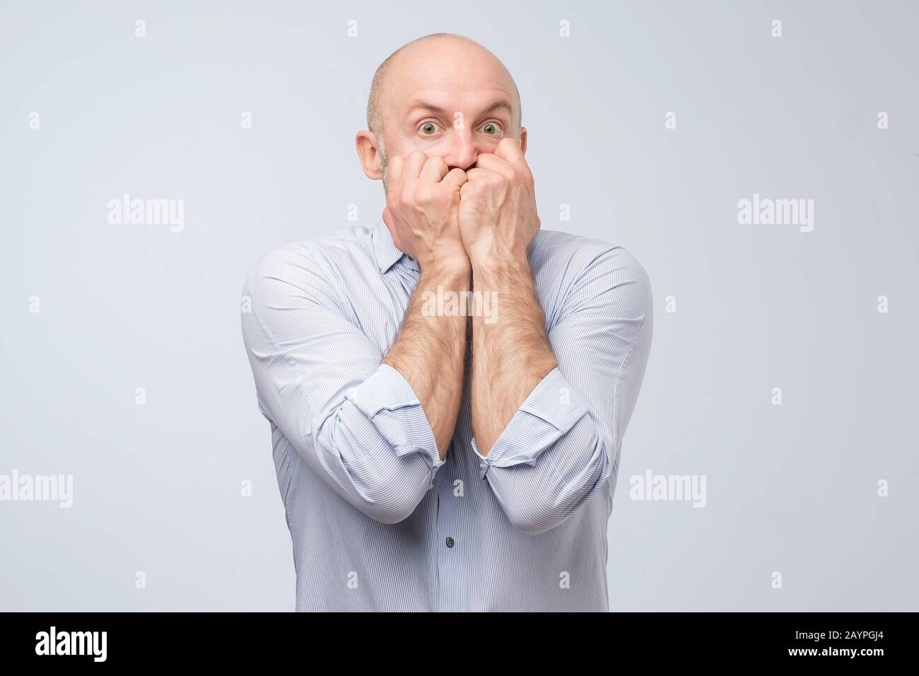 Scared mature man covering mouth. Studio shot. Male saw a ghost. Studio ...