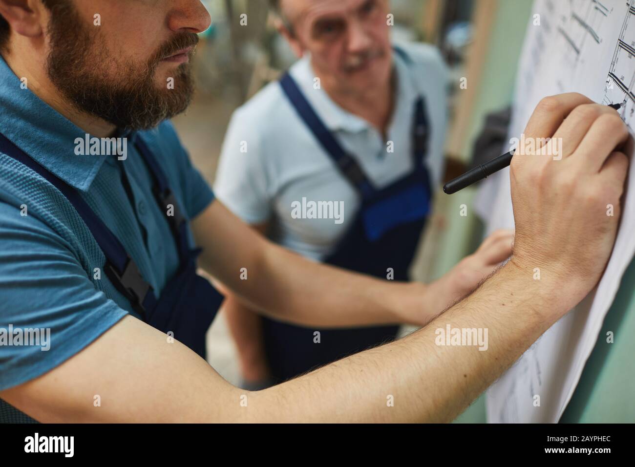 Close up of two construction workers looking at floor plans while ...