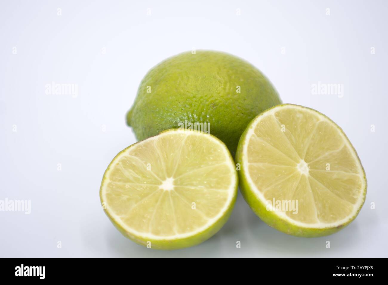 Closeup of whole lime with halved Lime white background studio Stock ...