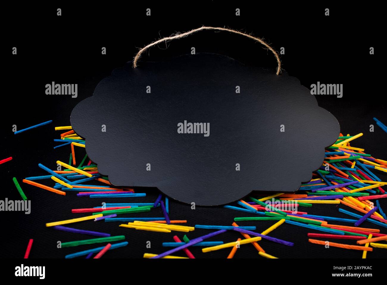 Black speech bubble shaped notice board on colorful sticks on black ...