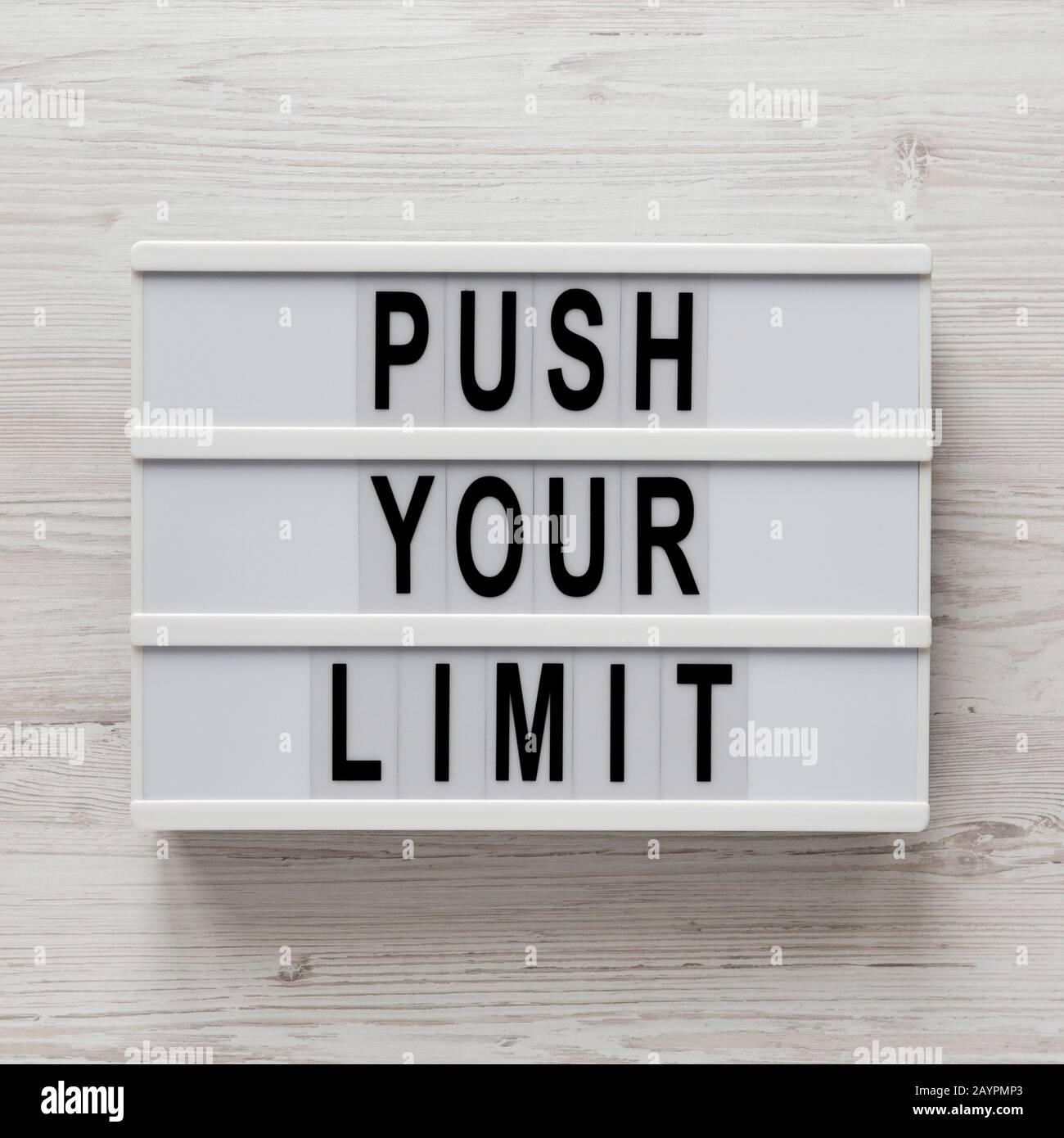 'Push your limit' words on a lightbox on a white wooden surface, top ...