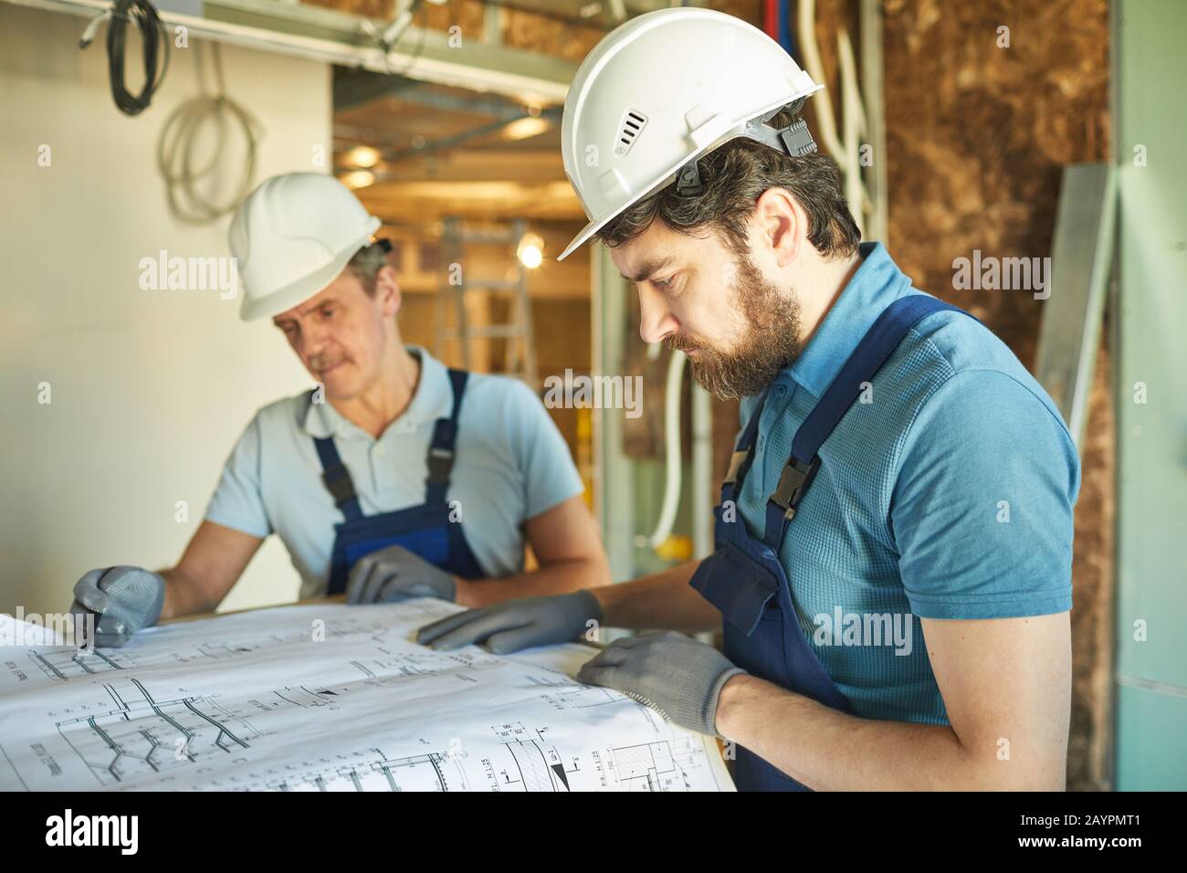 Side view portrait of bearded construction worker wearing hardhat while ...