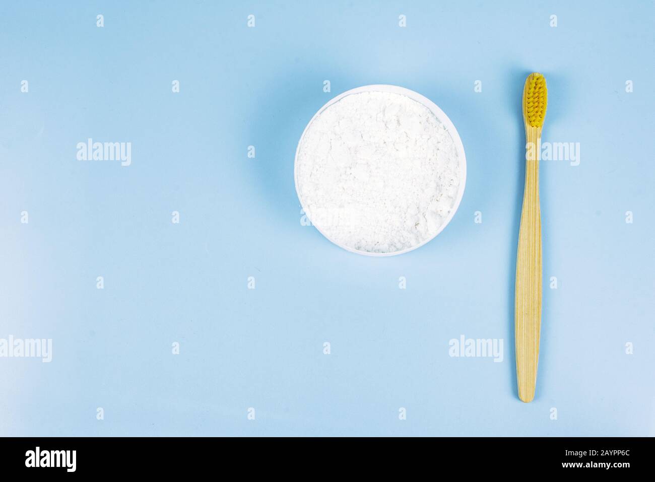 Bamboo toothbrush and powder for cleaning teeth on an blue background ...