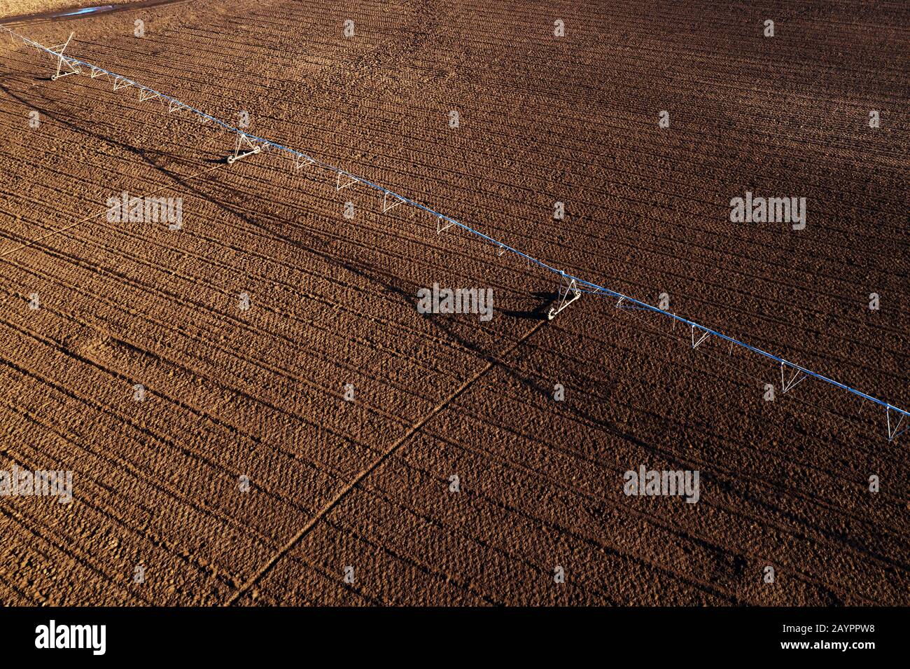 Aerial view of center-pivot irrigation system on plowed field from ...