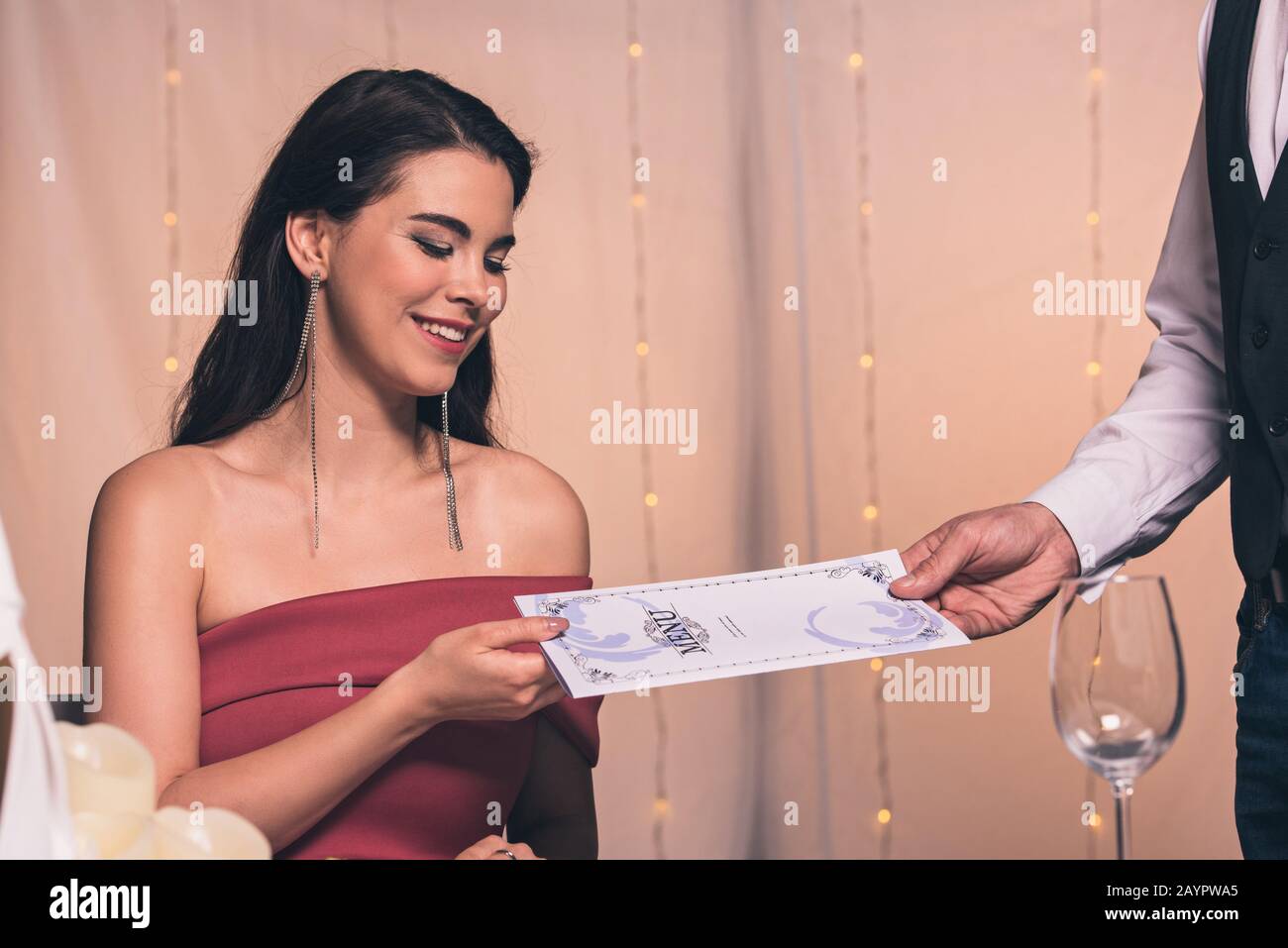 cropped view of waiter giving menu to attractive, elegant girl in ...