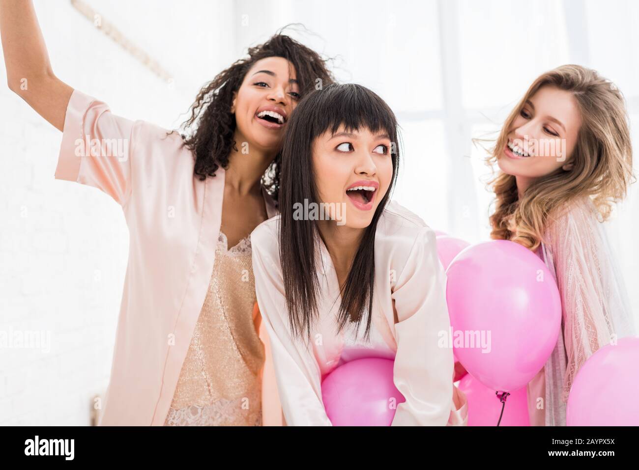 excited multicultural girls having bachelorette party with pink ...