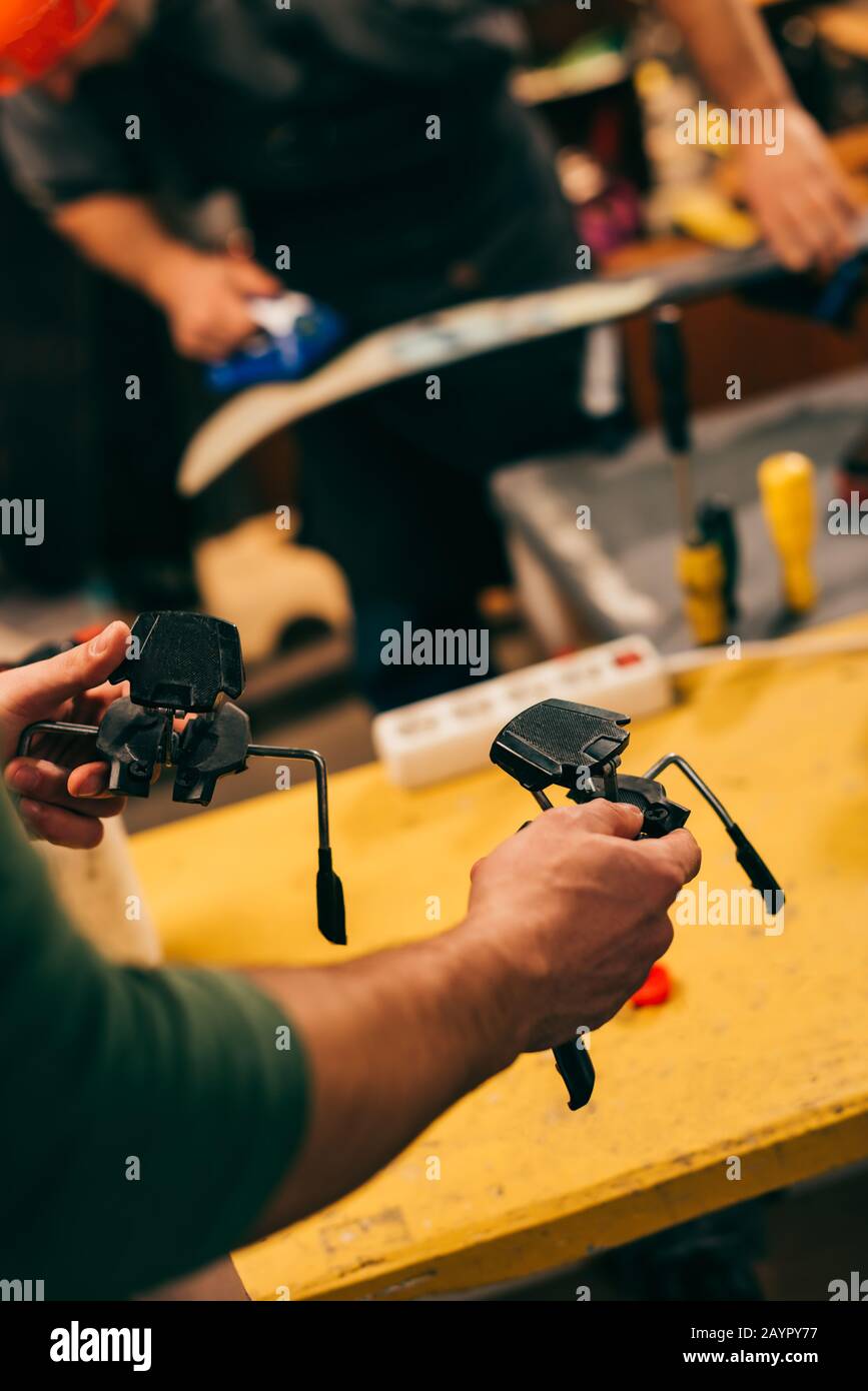 cropped view of worker holding grip vices in repair shop Stock Photo ...