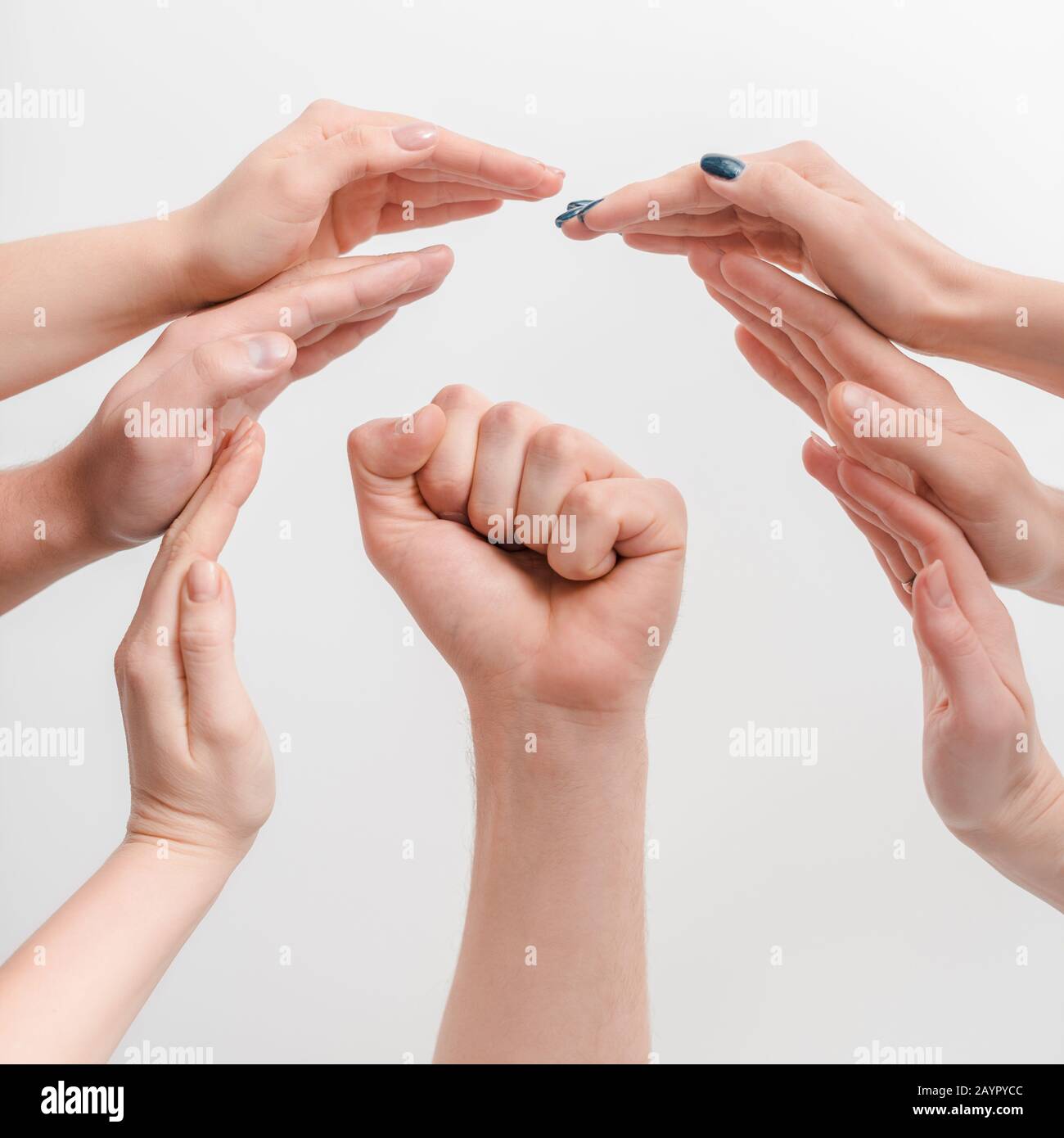 cropped view of women protecting hand of man with clenched fist ...