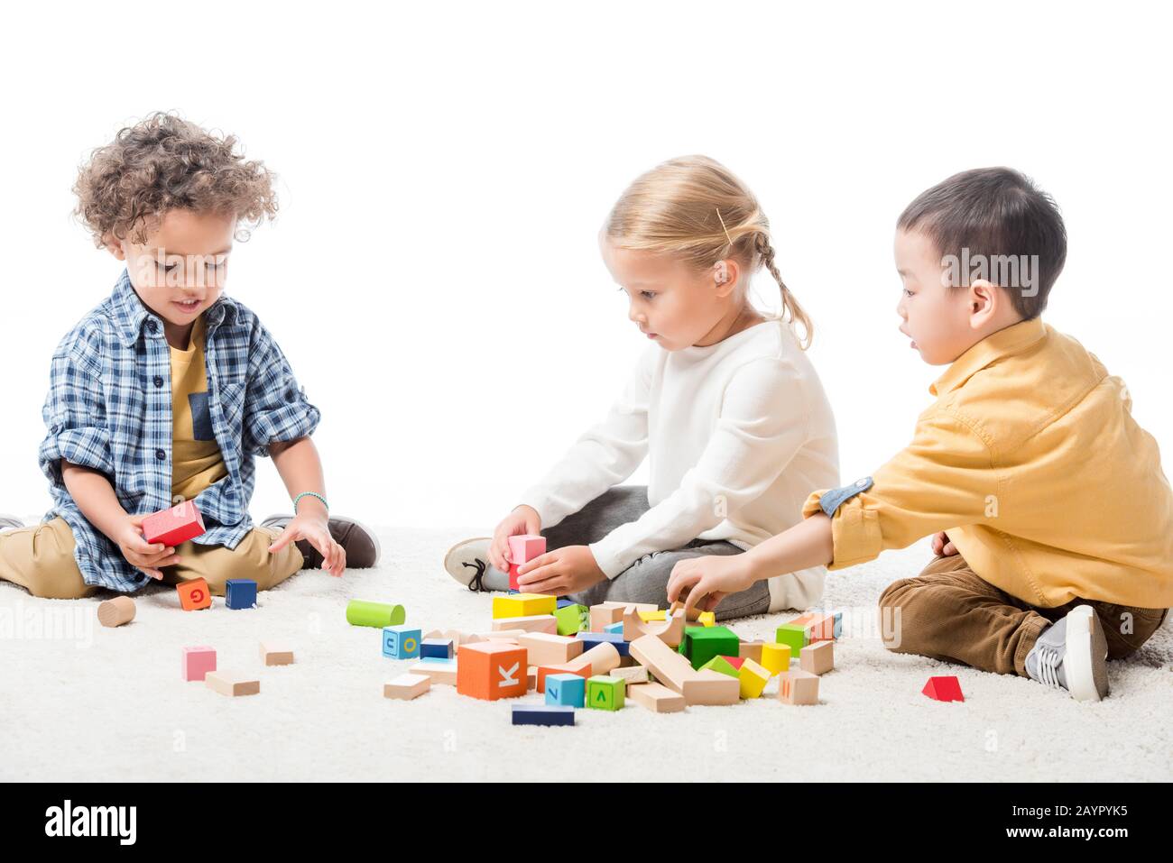 multicultural kids playing with wooden blocks on carpet, isolated on ...