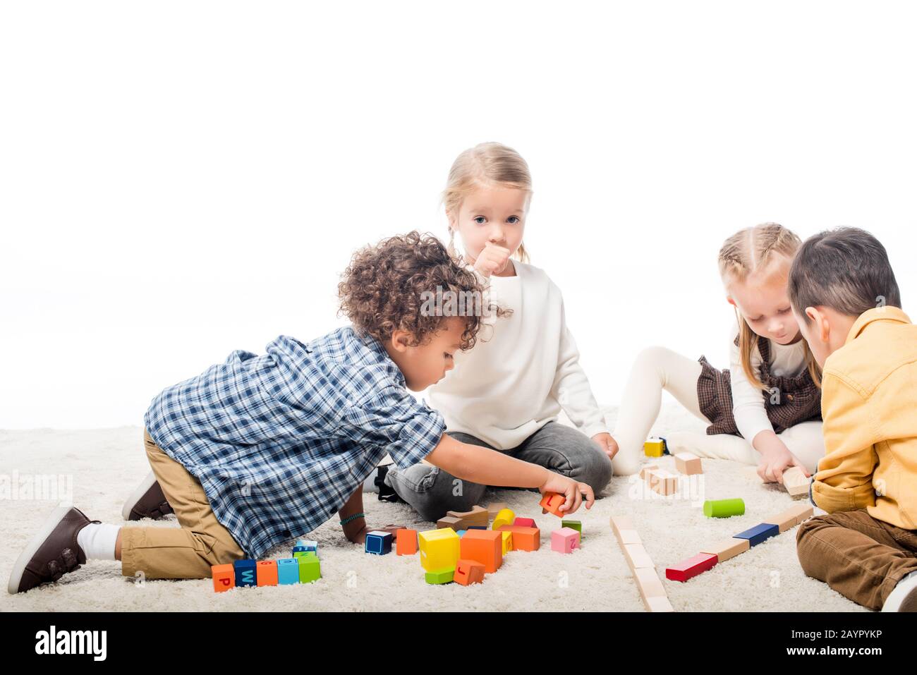multicultural kids playing with wooden blocks on carpet, isolated on ...