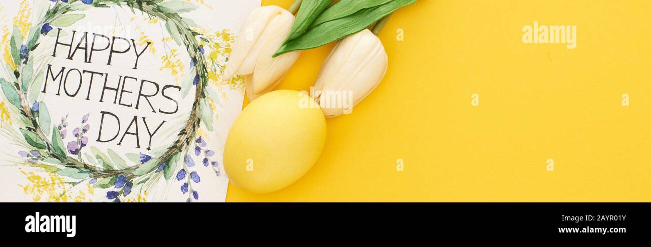 top view of spring tulips, Easter egg and happy mothers day greeting ...
